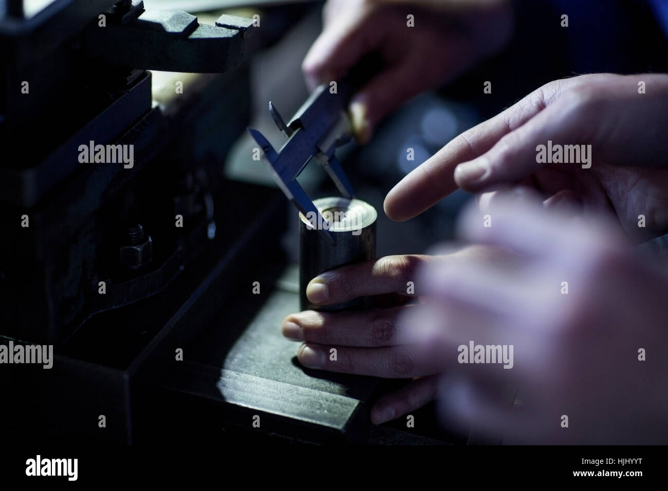 Two people using Vernier caliper in workshop to measure diameter Stock ...