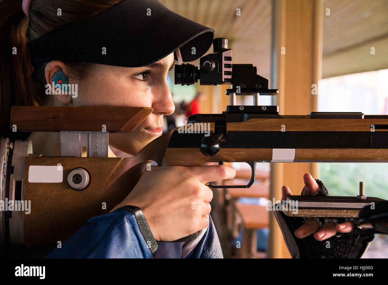 Woman with a sporting rifle aiming in a shooting range Stock Photo - Alamy
