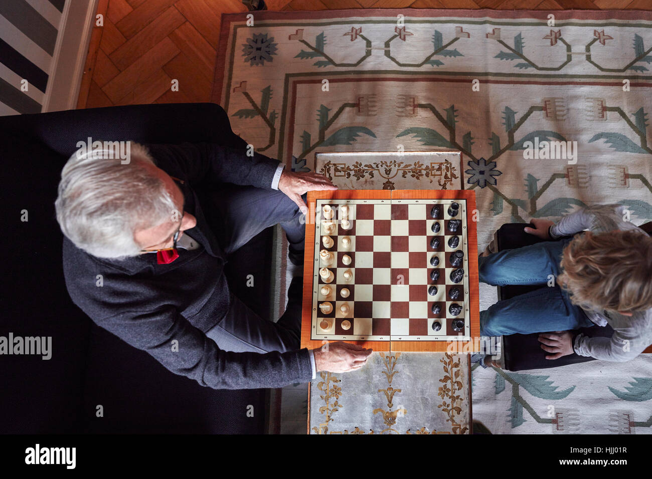 Grandfather and grandson playing chess in living room Stock Photo - Alamy