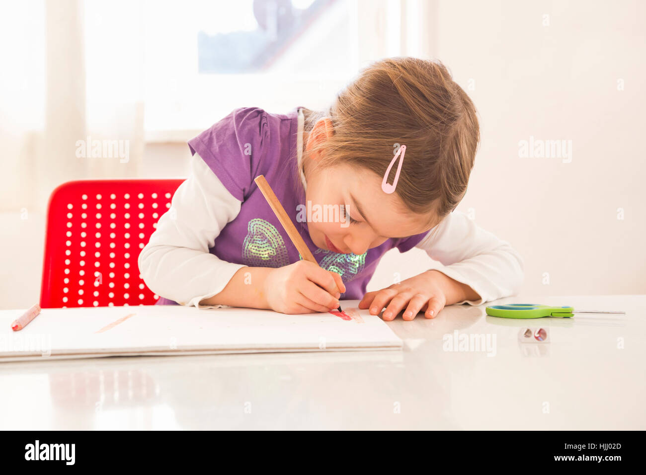 Little girl making a drawing on sheet of paper Stock Photo - Alamy