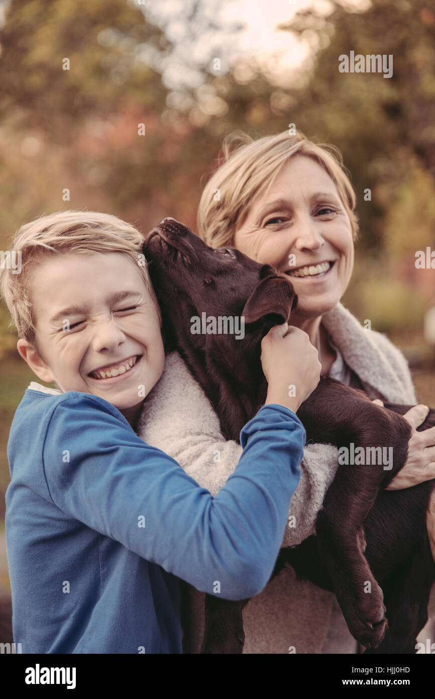 Boy and woman cuddling with Labrador Retriever Stock Photo - Alamy
