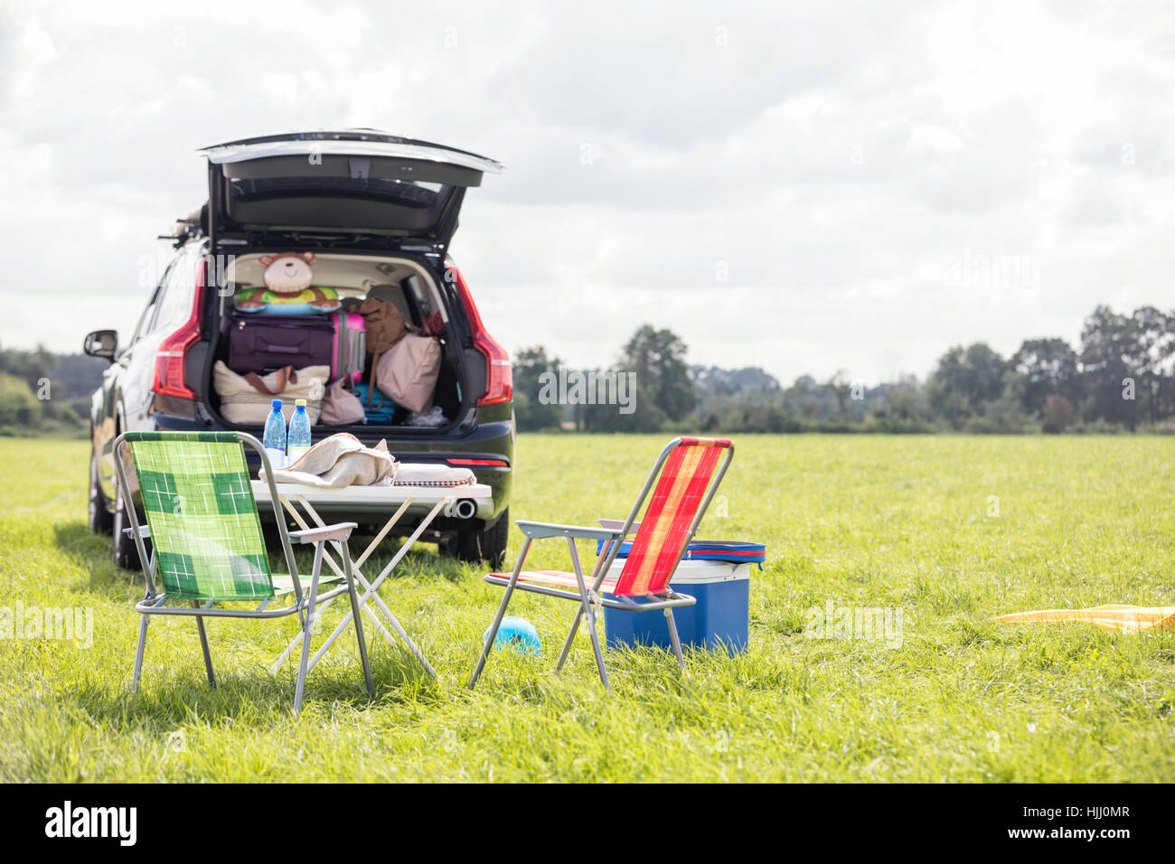 Car on meadow with open boot full of luggage Stock Photo - Alamy