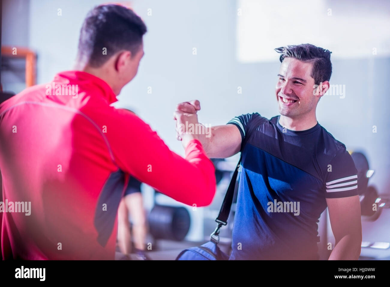 Two young men shaking hands in gym Stock Photo - Alamy