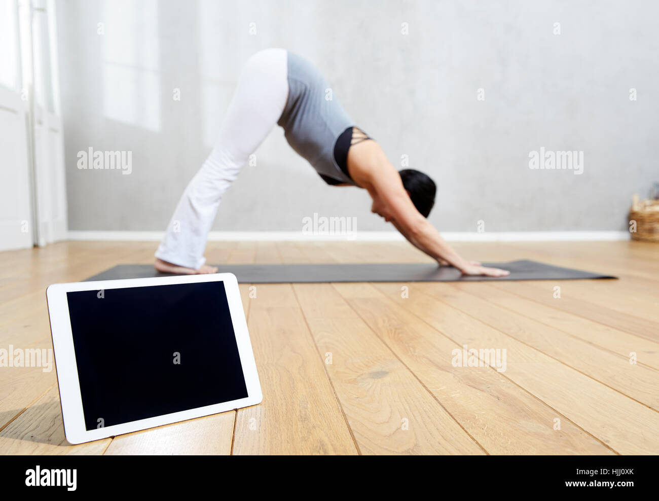 Woman practising yoga behind tablet Stock Photo - Alamy