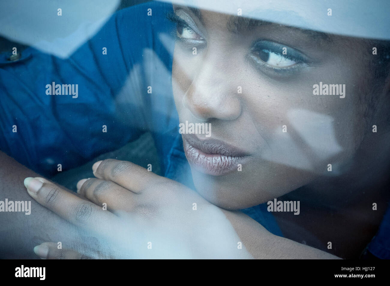 Young woman looking out of window Stock Photo - Alamy