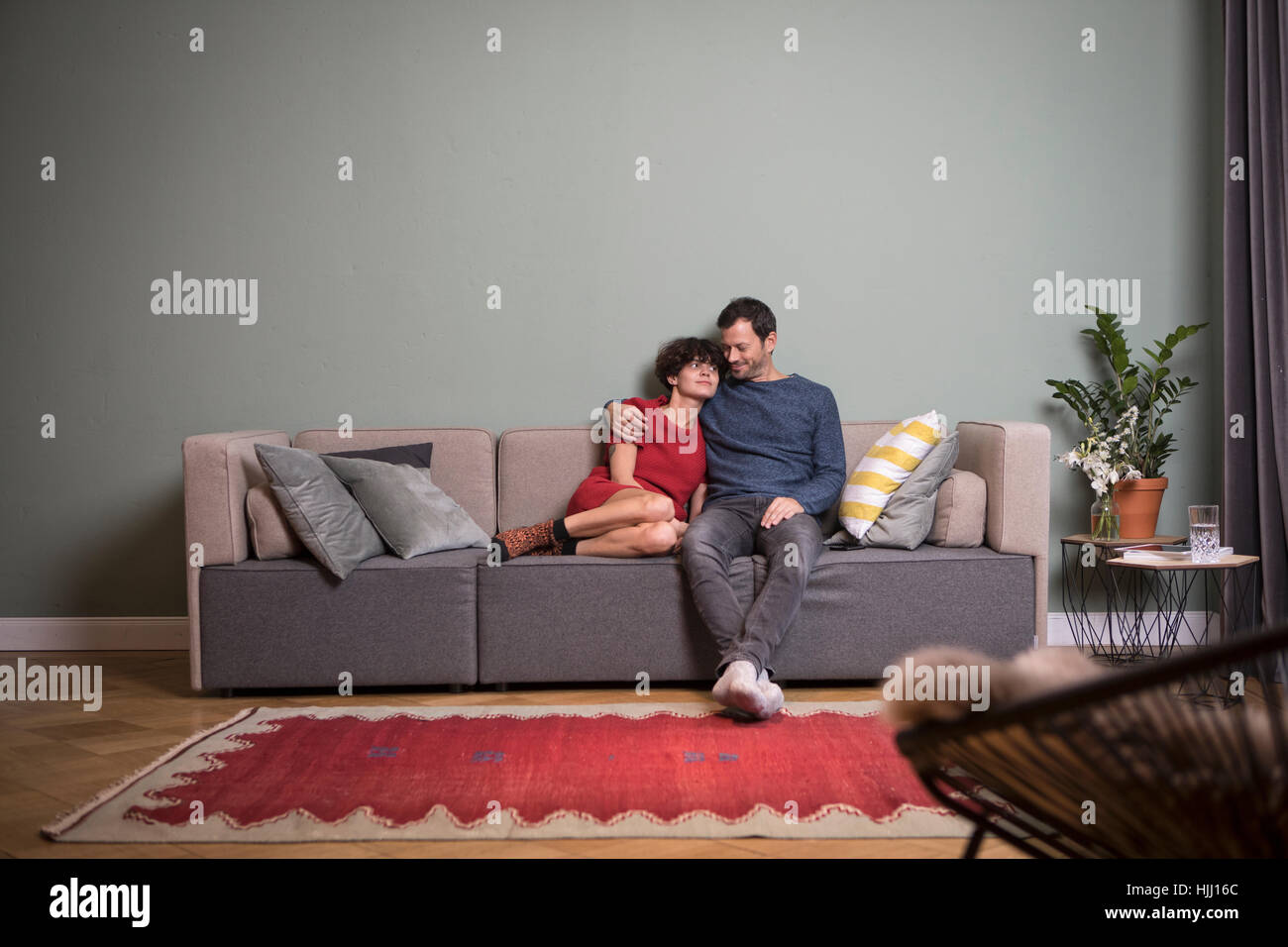 Couple sitting together on the couch Stock Photo - Alamy
