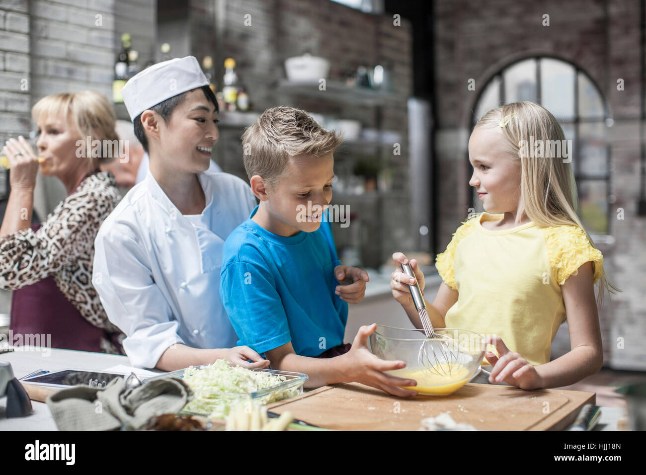 Kids and adults taking cooking course Stock Photo - Alamy
