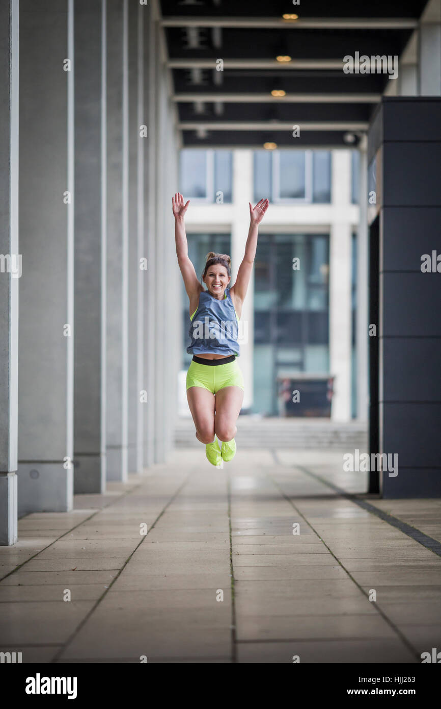 Sportive woman jumping at arcade Stock Photo - Alamy