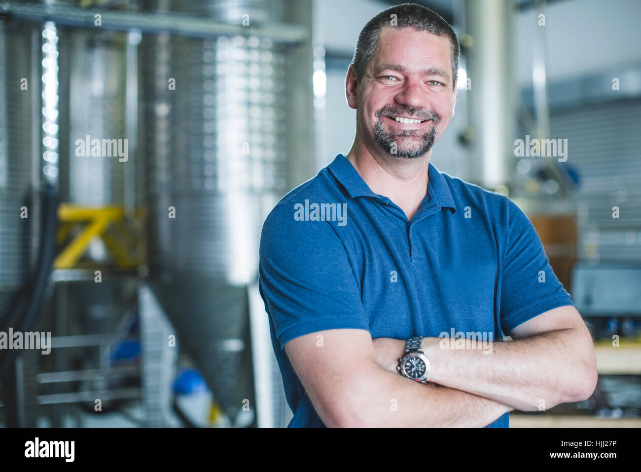 Master distiller standing in distillery with arms crossed Stock Photo ...