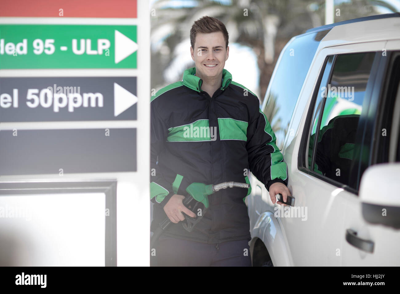 Portrait of petrol attendant fueling car Stock Photo - Alamy