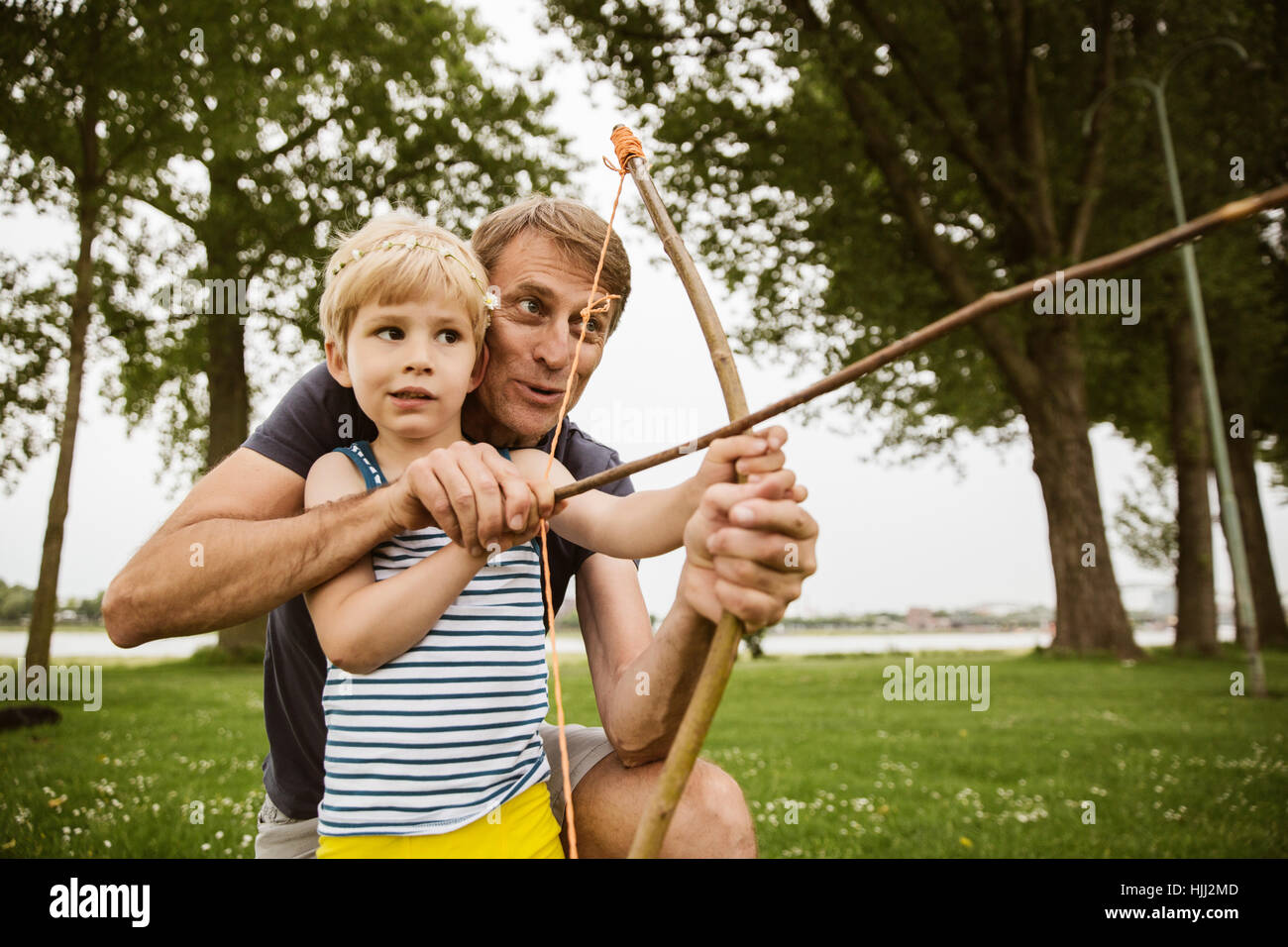 Father and son playing with self made bow and arrow Stock Photo - Alamy