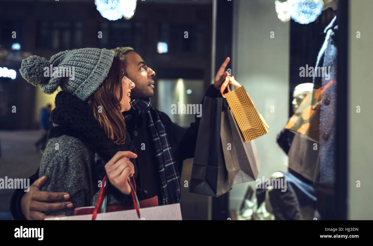 Young couple looking in shop window Stock Photo - Alamy