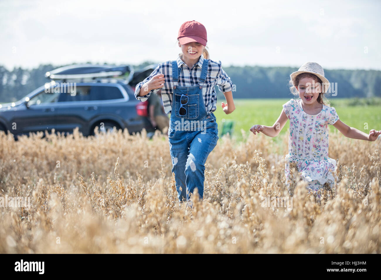 Two laughing girls running in field Stock Photo - Alamy