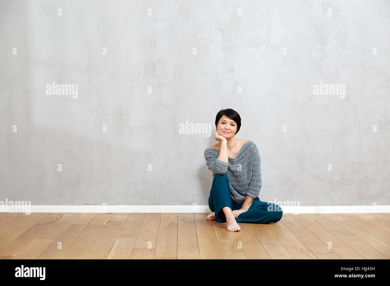 Portrait of woman sitting on floor Stock Photo - Alamy