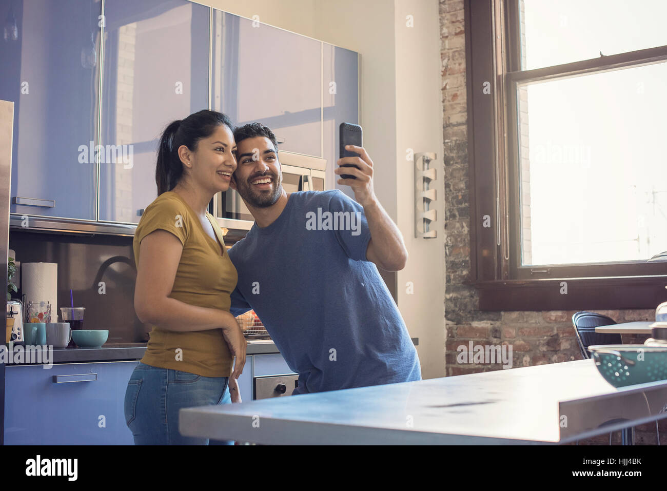 Young couple in kitchen taking selfie Stock Photo - Alamy