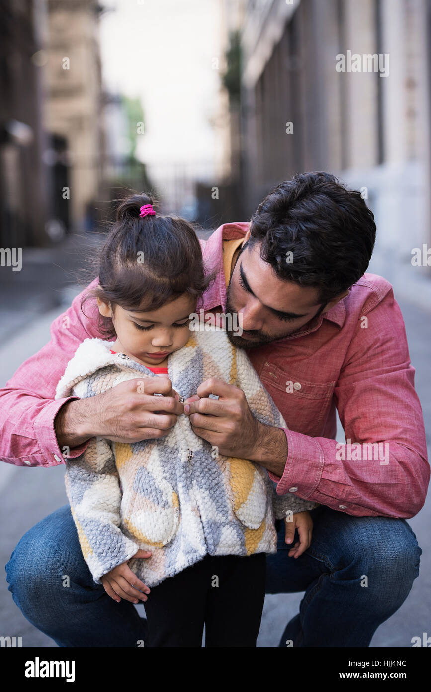 Father dressing daughter in warm coat Stock Photo - Alamy