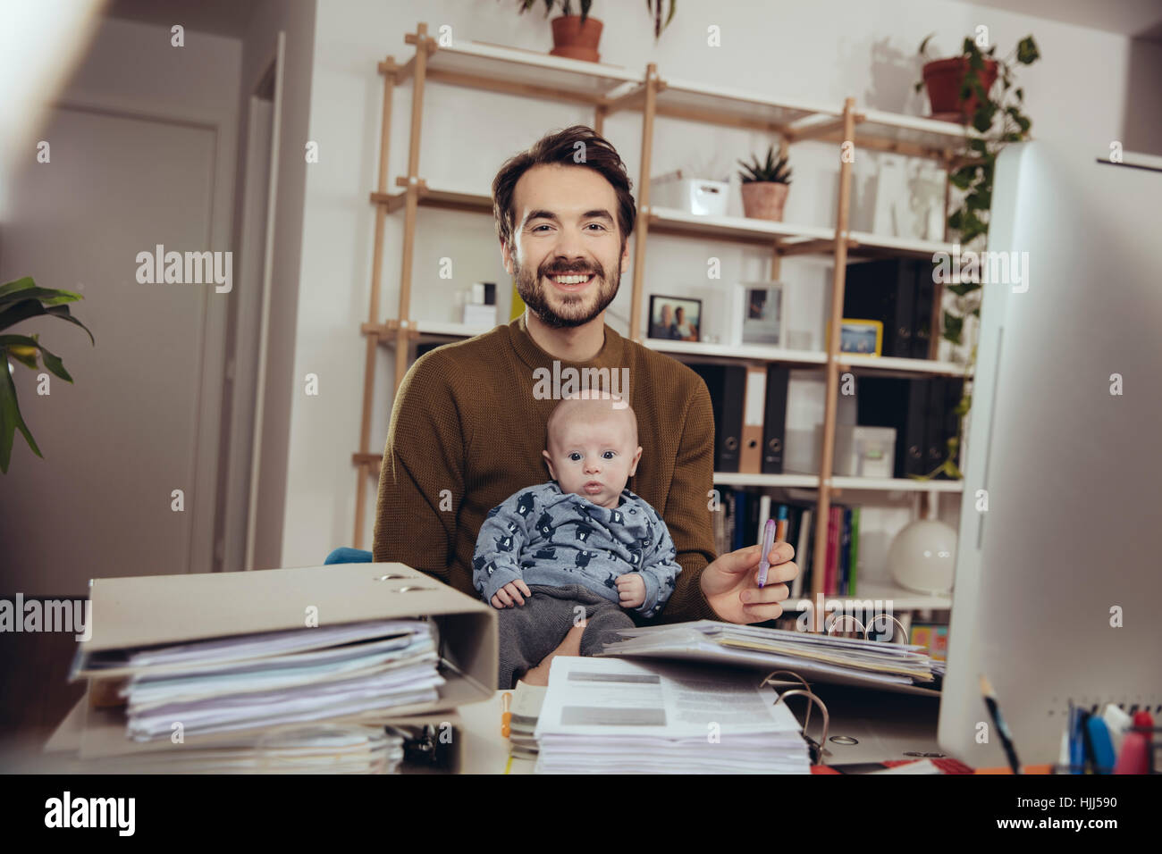 Portrait of smiling father with his baby in home office Stock Photo - Alamy