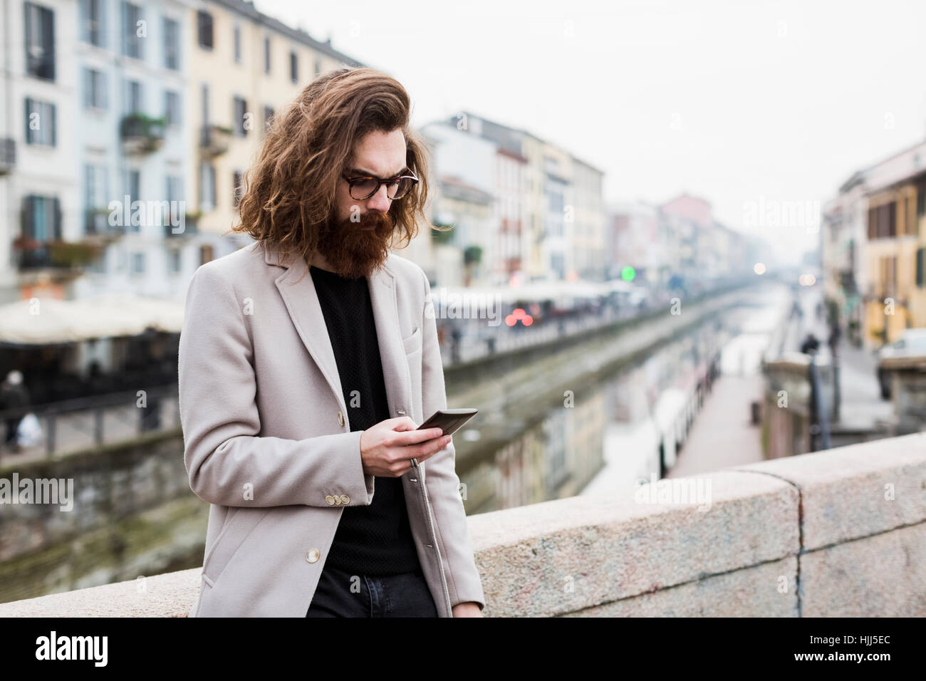 Stylish young man outdoors checking cell phone Stock Photo - Alamy