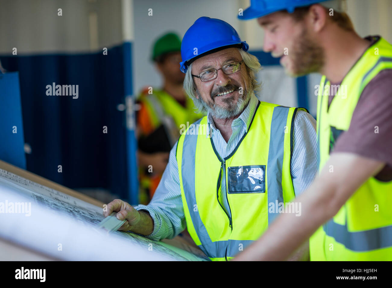 Construction worker and engineer discussing project in site office ...