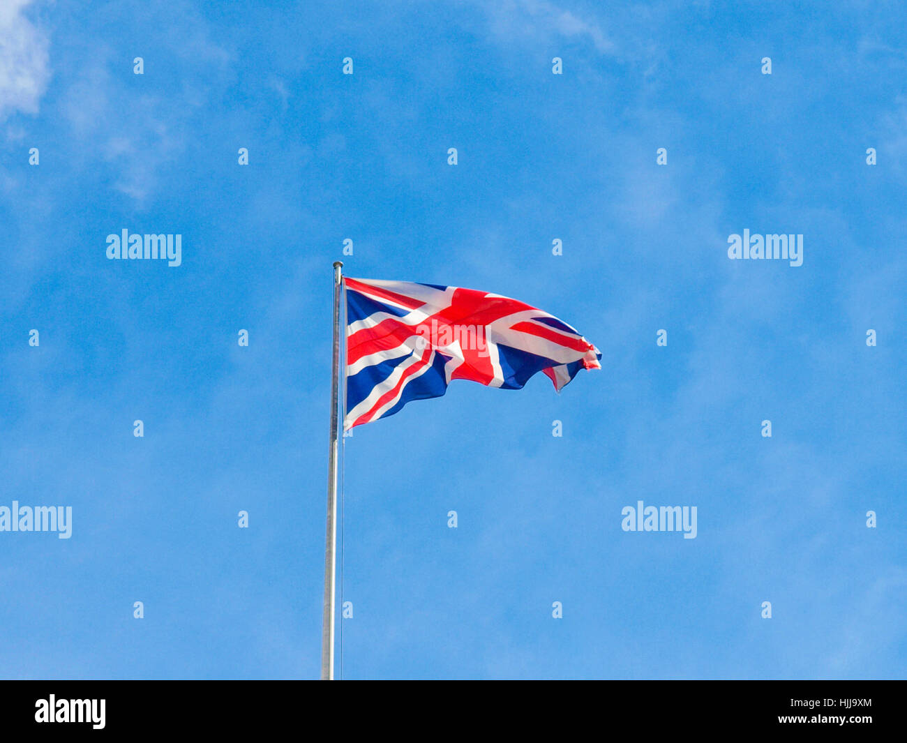 Union Jack national flag of the United Kingdom (UK) - over blue sky ...