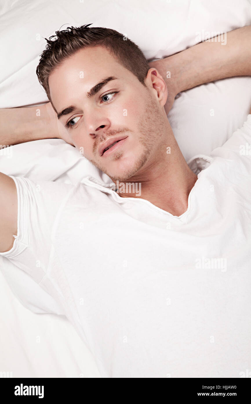beautiful young man lying in bed Stock Photo - Alamy
