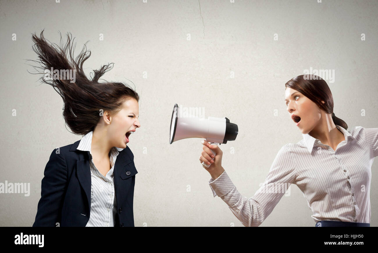 Furious woman screaming agressively in megaphone at woman hi-res stock ...