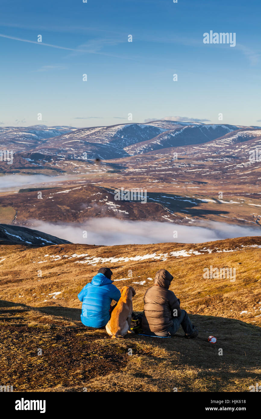 A couple and their dog on the summit of the mountain of Ben Vrackie ...