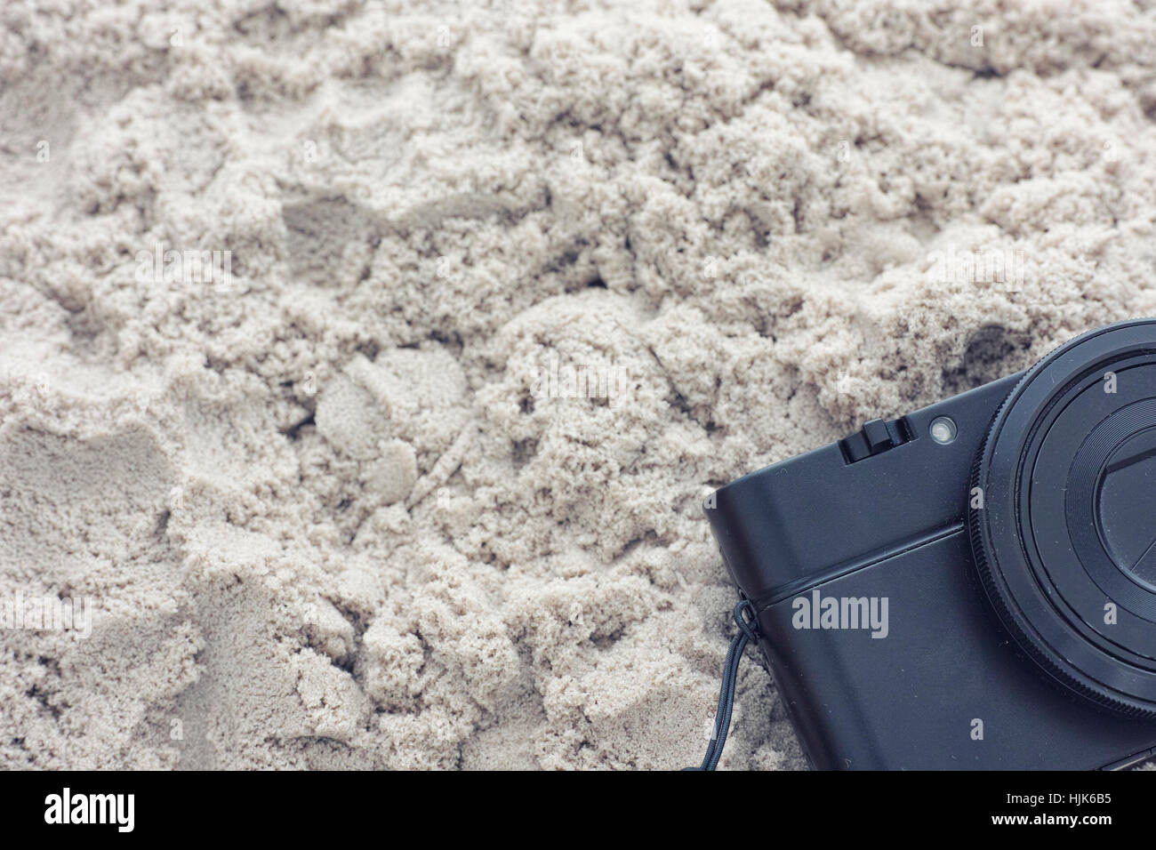 Black pocket camera laying on sand. Close up Stock Photo - Alamy