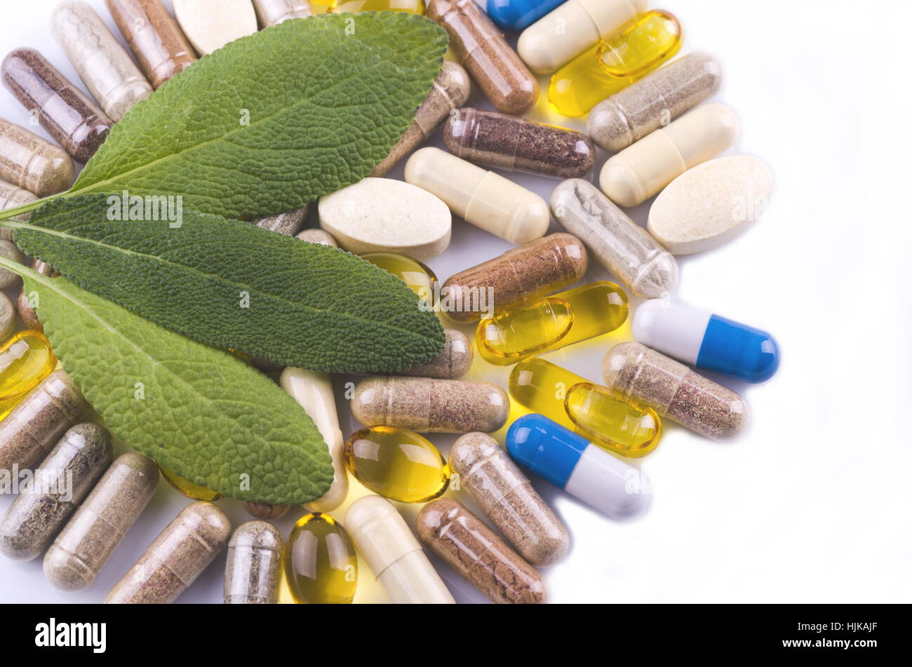 herbal capsules and herbal leaves isolated on white background Stock ...