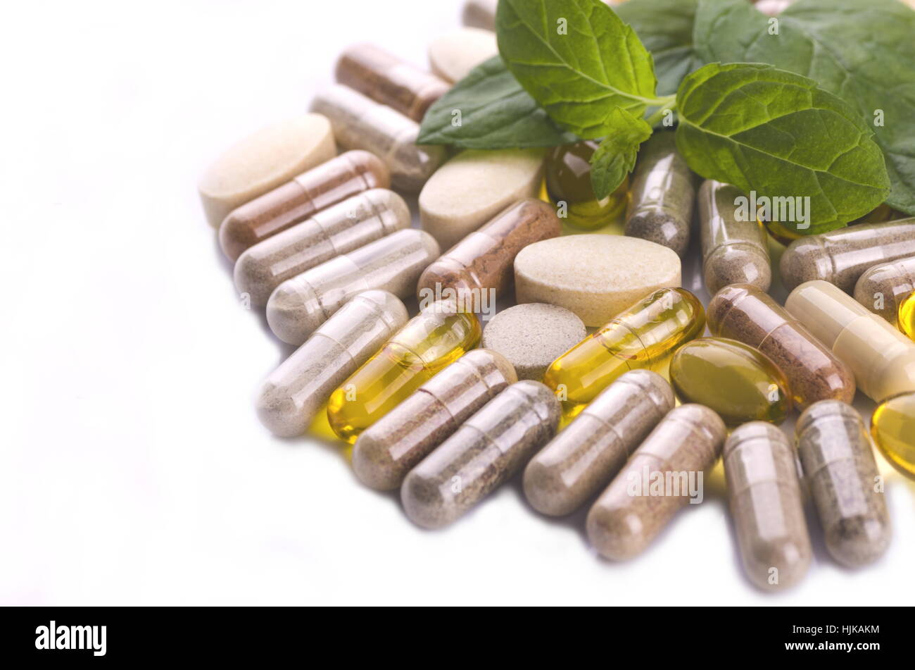 herbal capsules and herbal leaves isolated on white background Stock ...