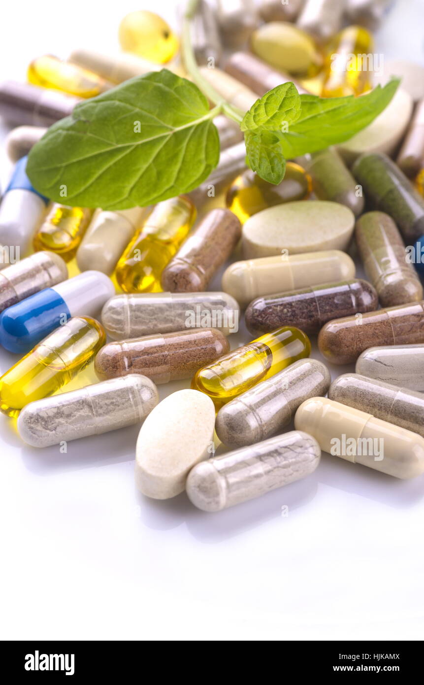 herbal capsules and herbal leaves isolated on white background Stock ...