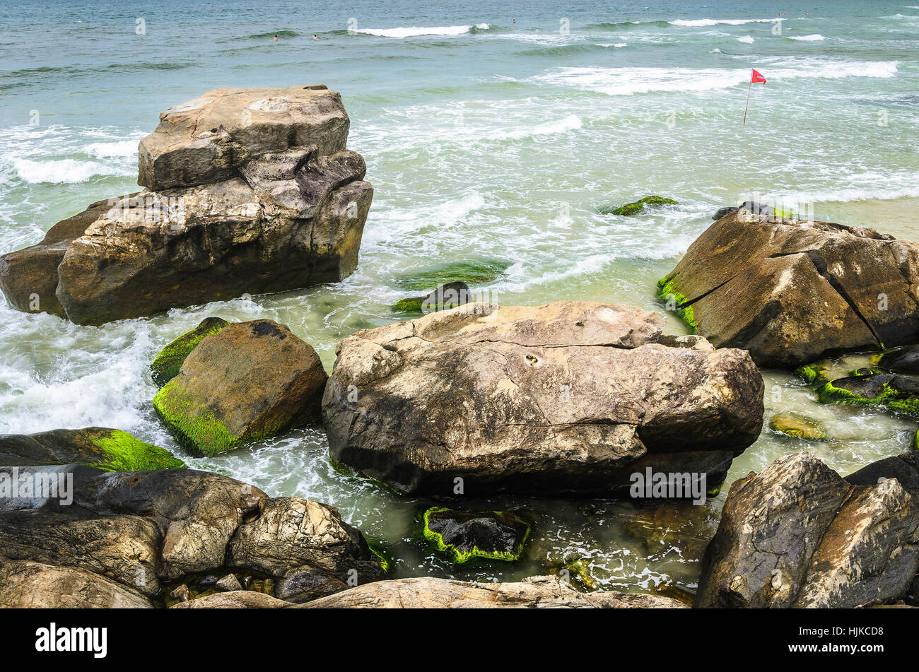 Beautiful scene with stones with green moss on the seashore, sea water ...