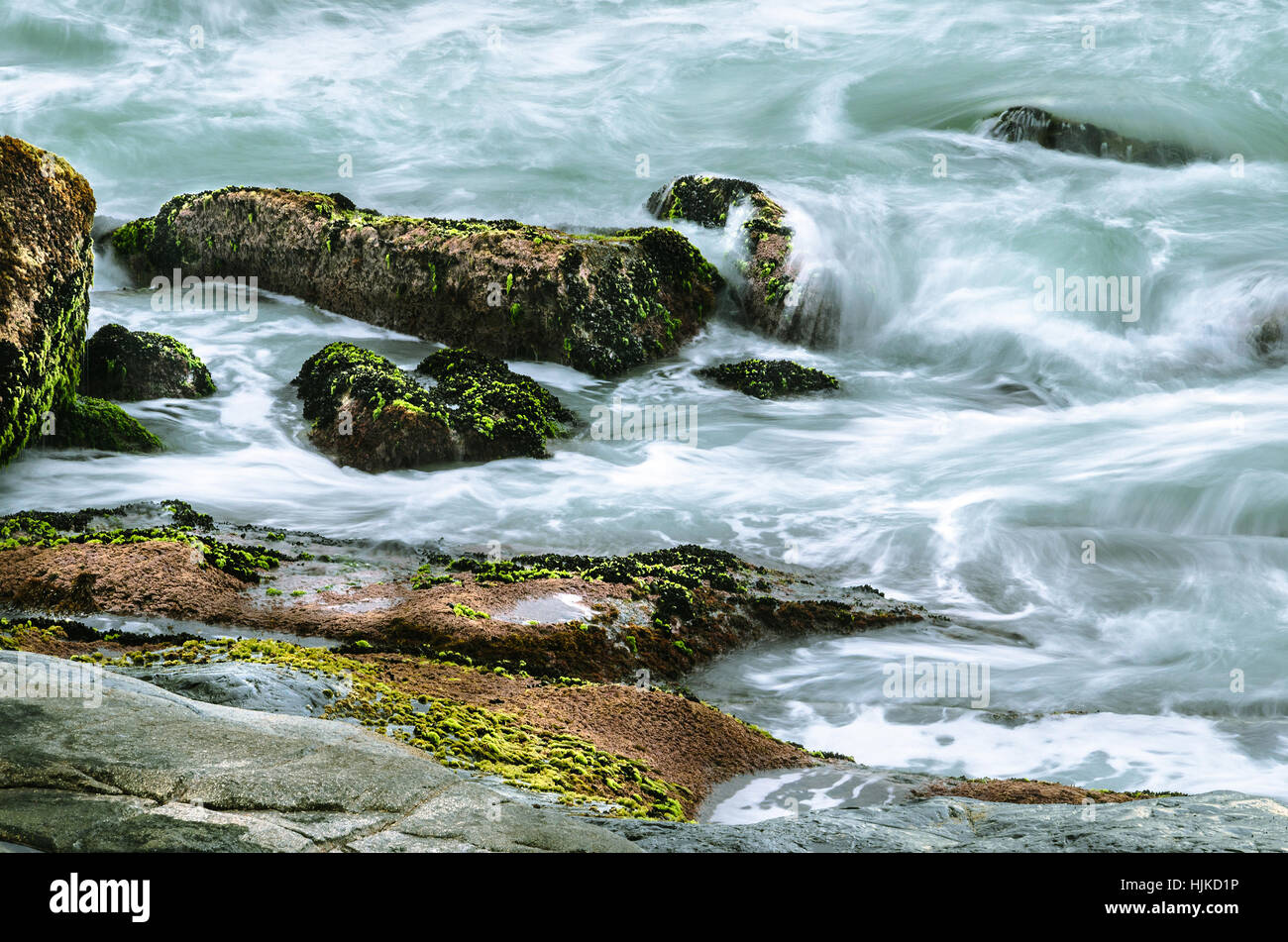 Long exposure photo of sea water running over the rocks Stock Photo - Alamy