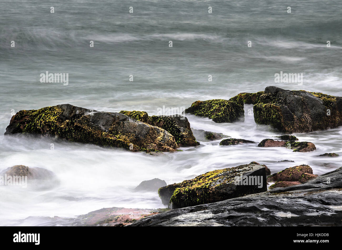 Long exposure photo of sea water running over the rocks. Rocks with ...