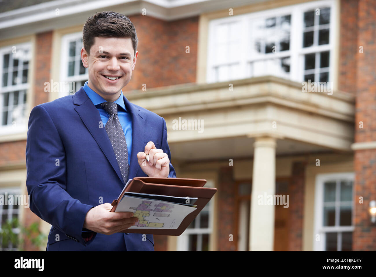 Male Realtor Standing Outside Residential Property Stock Photo - Alamy
