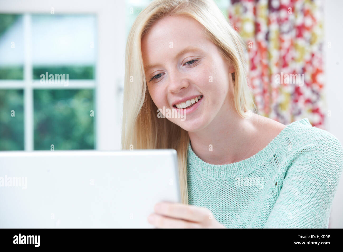Smiling Teenage Girl Using Computer At Home Stock Photo - Alamy
