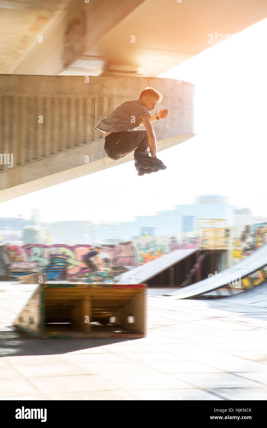 Guy on rollerblades jumping Stock Photo - Alamy