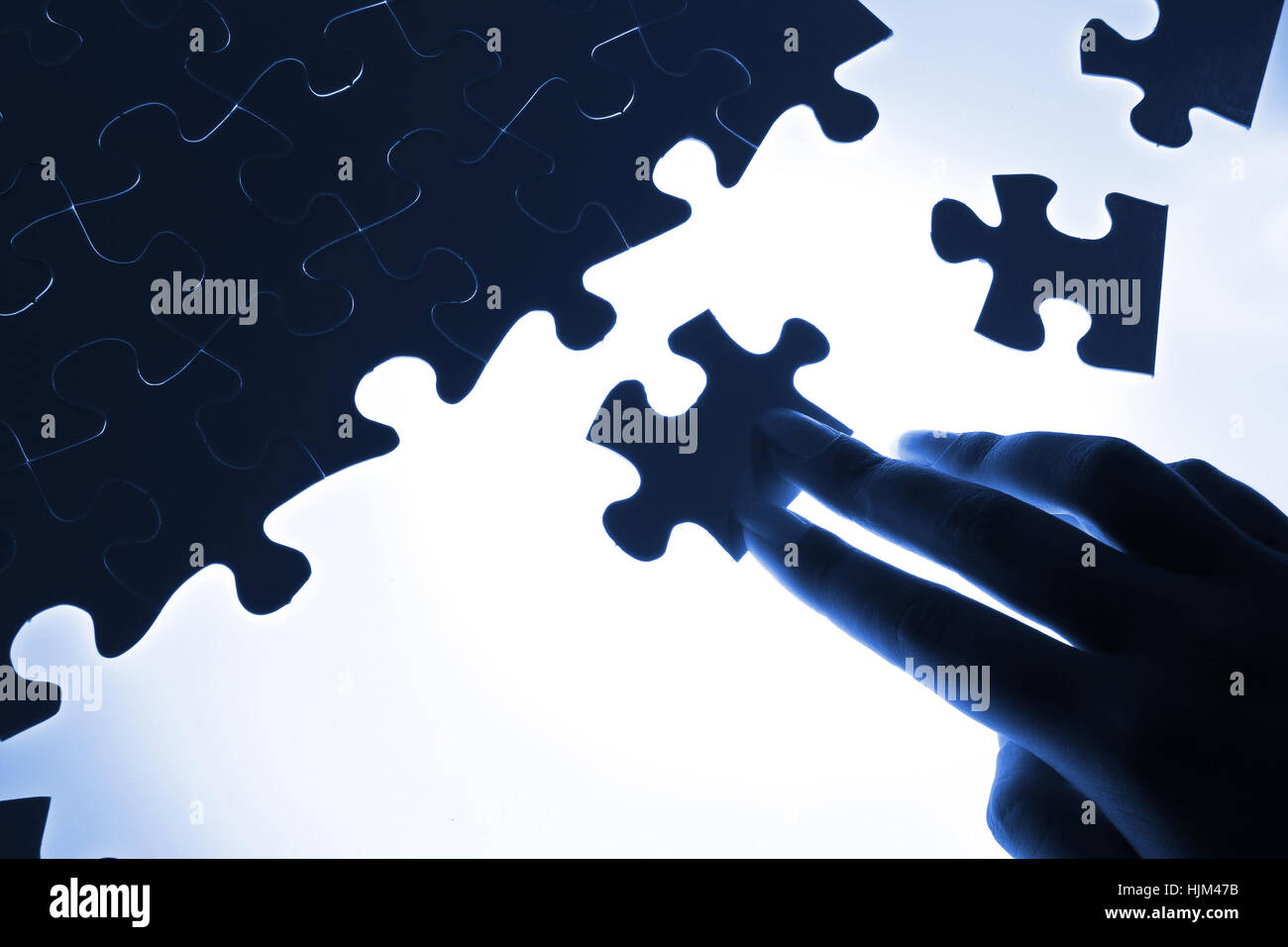 puzzle piece coming down into its place Stock Photo - Alamy