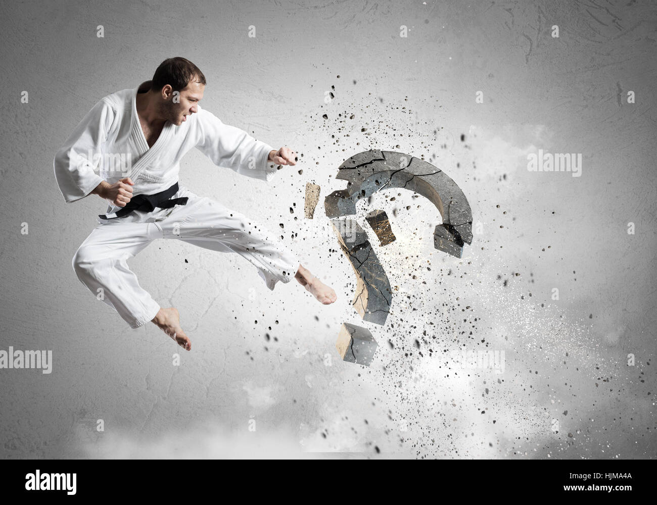 Young determined karate man breaking with leg concrete question sign ...