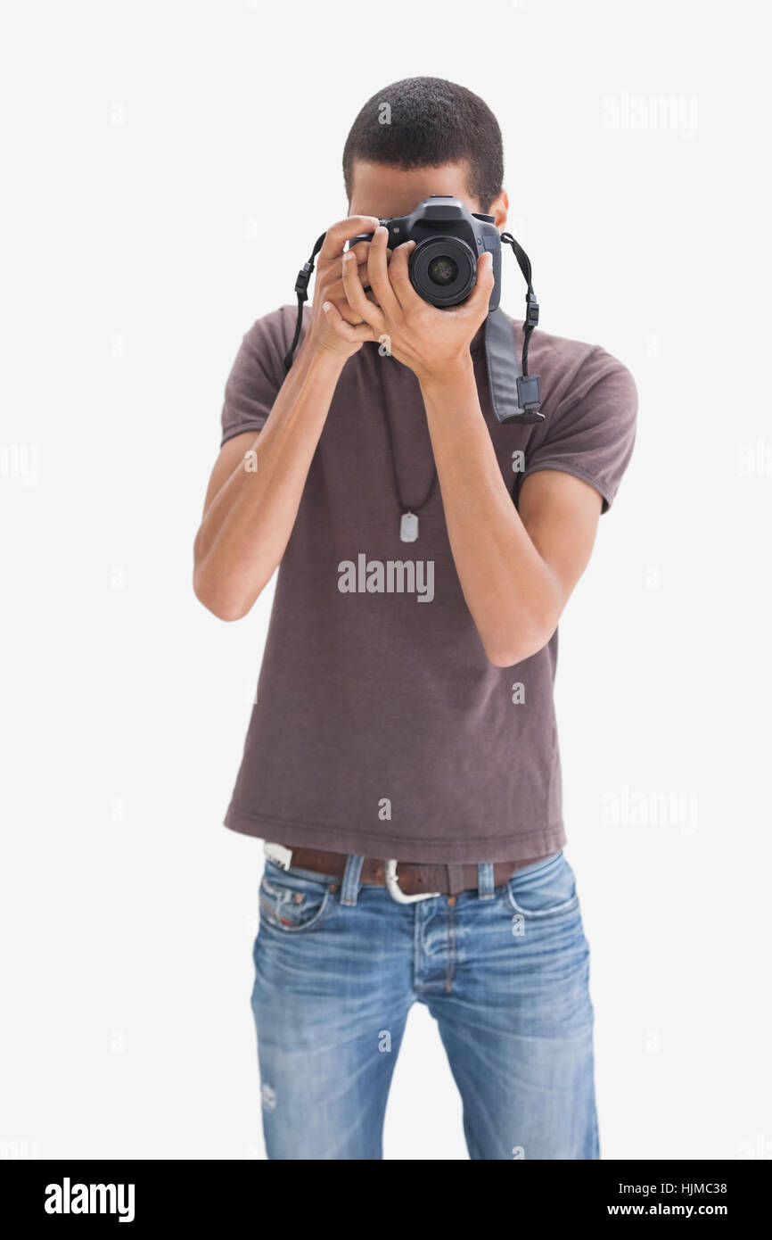 Hip young man pointing his camera at the camera on white background ...