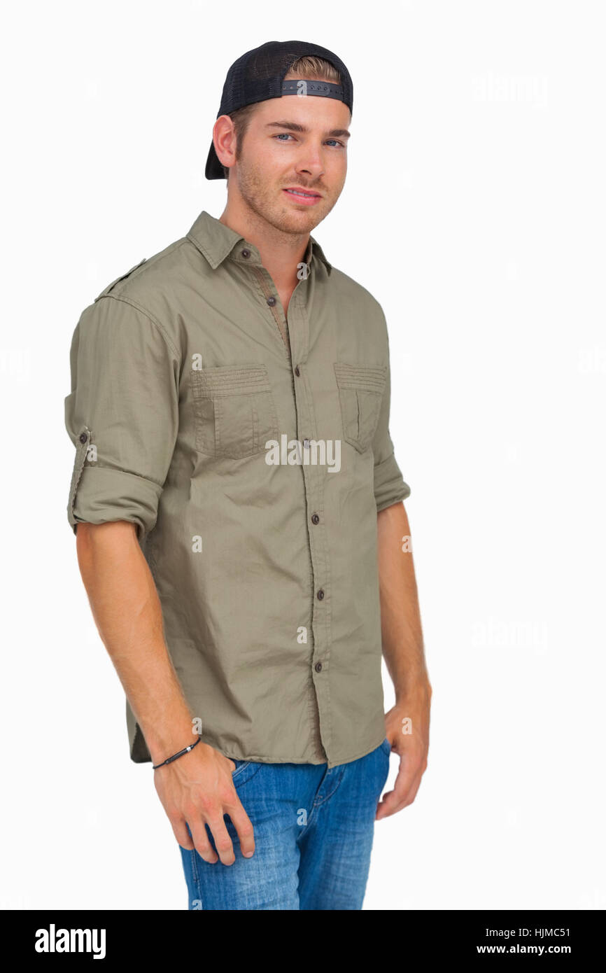 Man smiling and wearing baseball hat backwards on white background ...