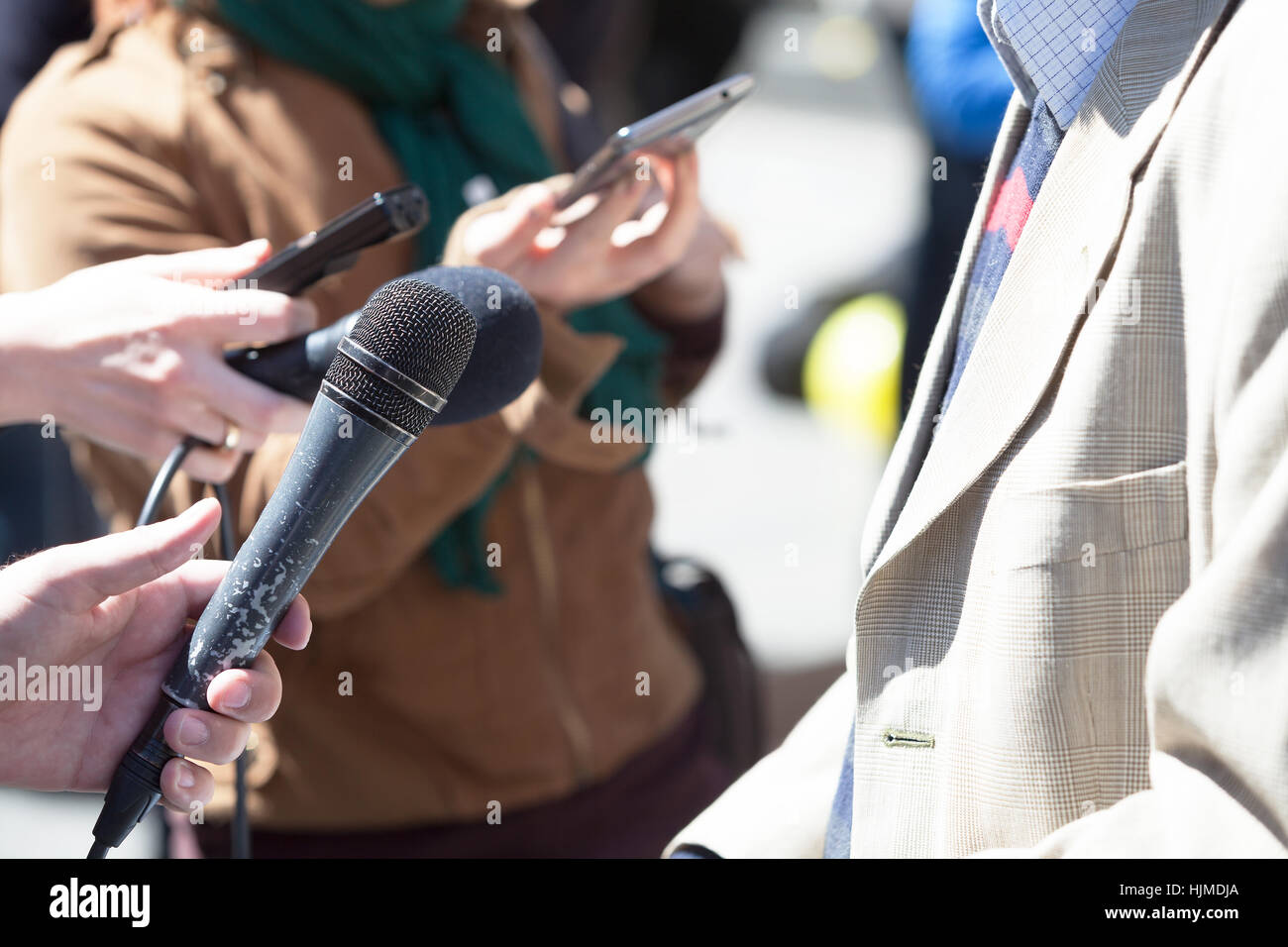 Reporter holding a microphone conducting an media interview Stock Photo - Alamy