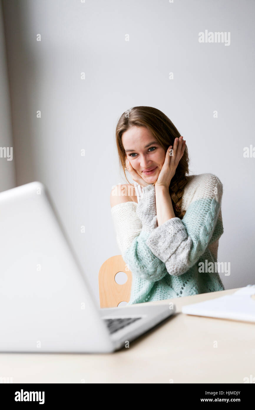 Excited young woman looking at her laptop Stock Photo - Alamy