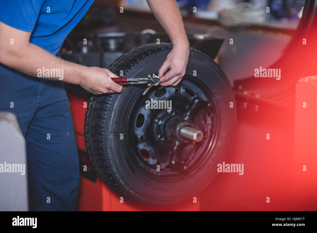 Mechanic checking tyre Stock Photo - Alamy