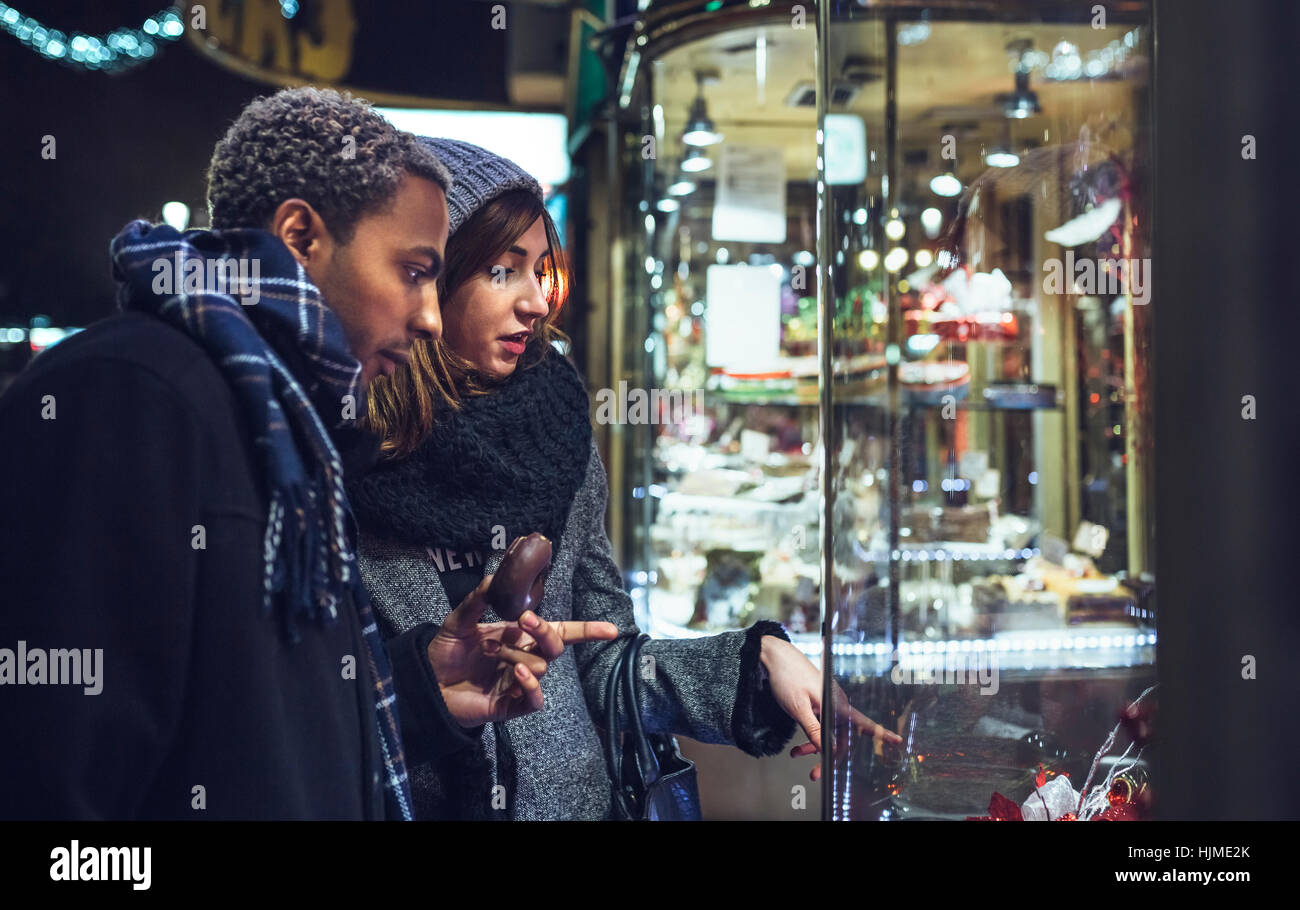 Young couple looking in shop window Stock Photo - Alamy