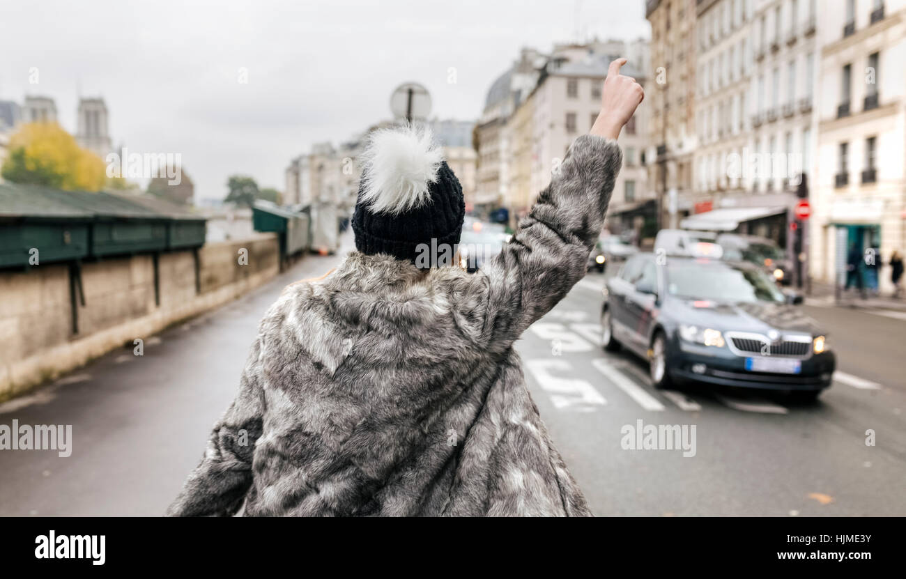France, Paris, back view of young woman hailing a taxi Stock Photo - Alamy