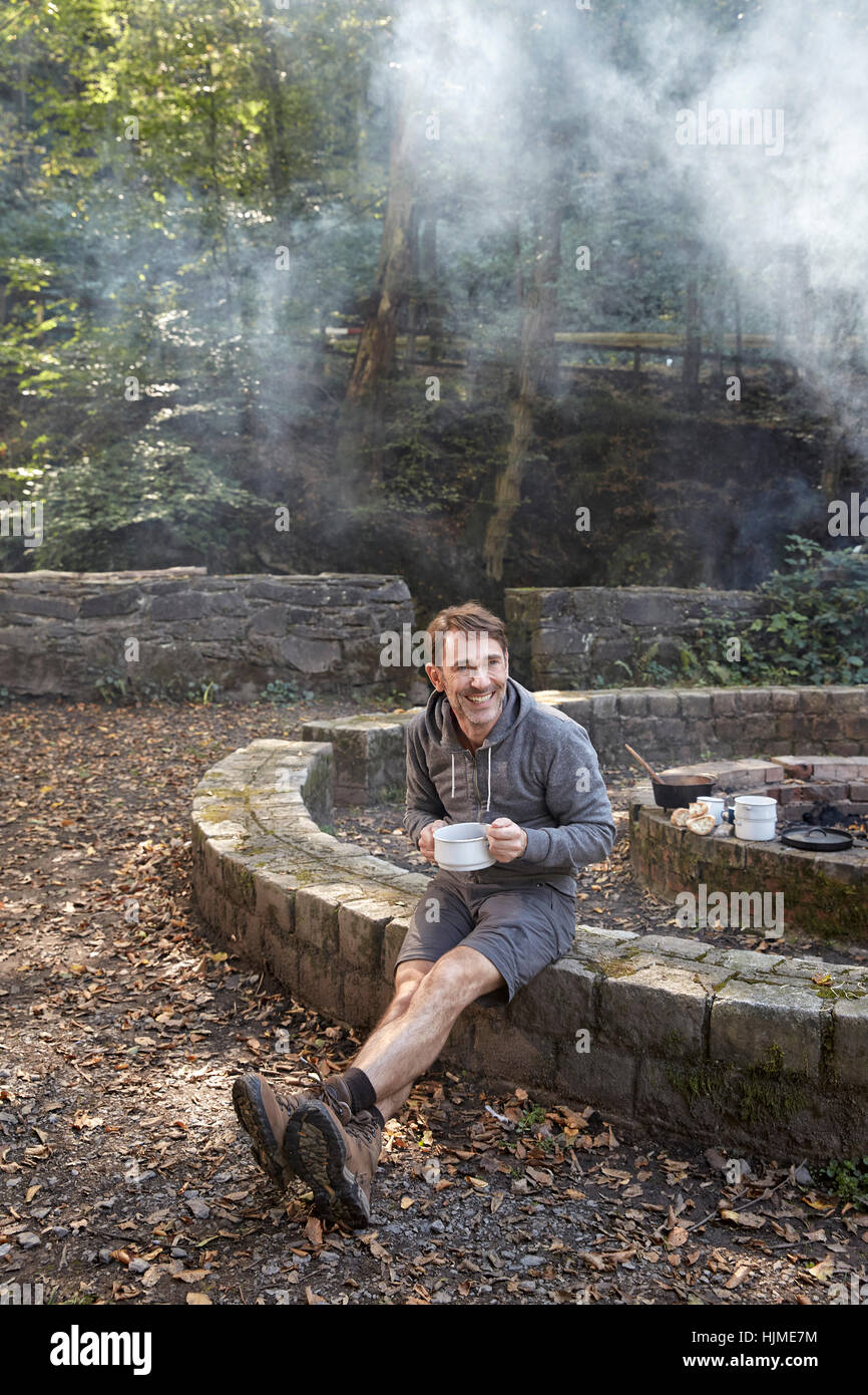 Man holding pot at camp fire Stock Photo - Alamy