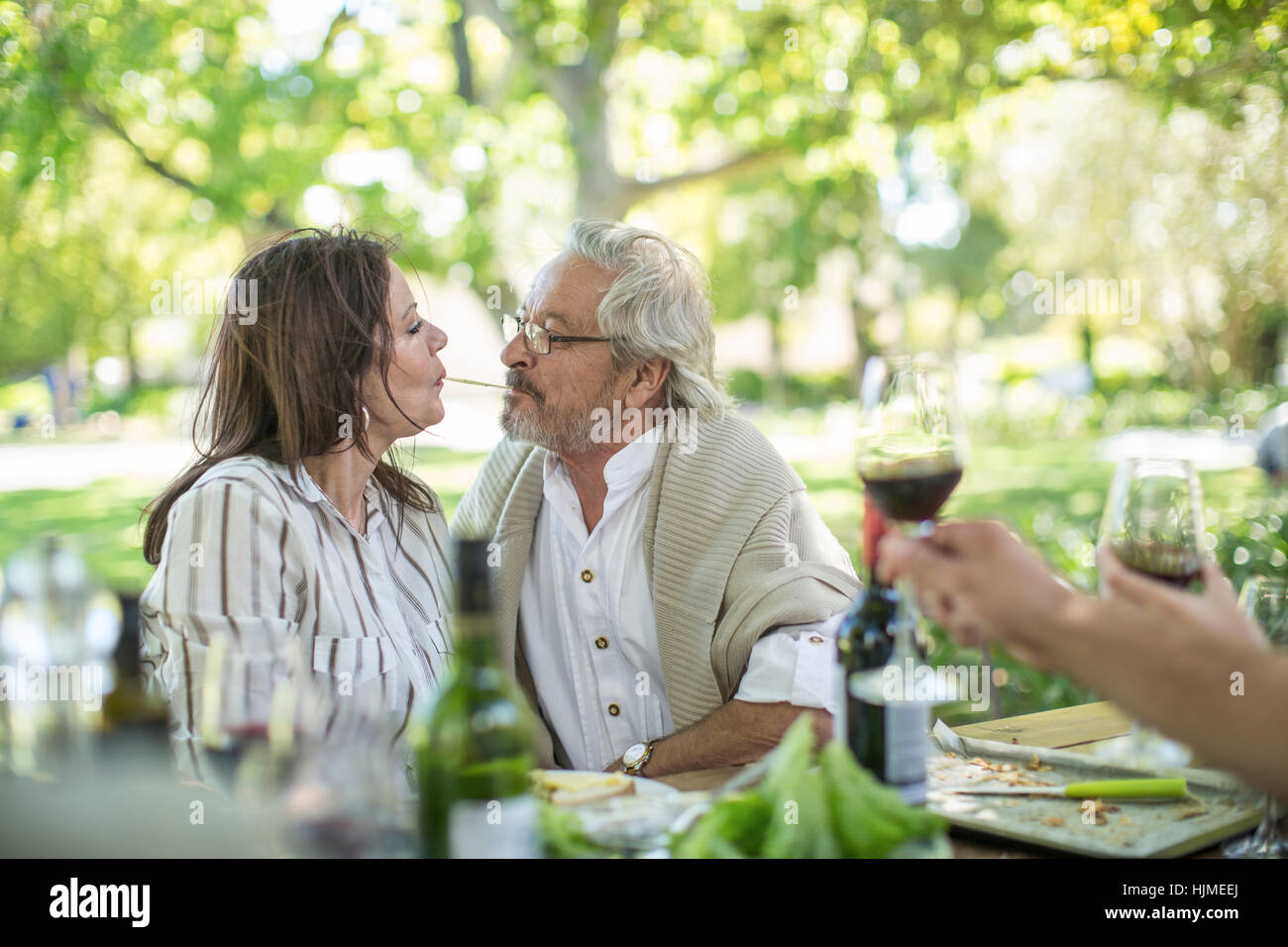 Senior couple sharing spaghetti at outdoor table Stock Photo - Alamy
