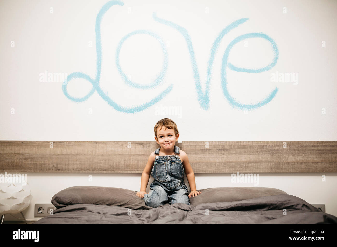Little boy crouching on the bed of his parents Stock Photo - Alamy