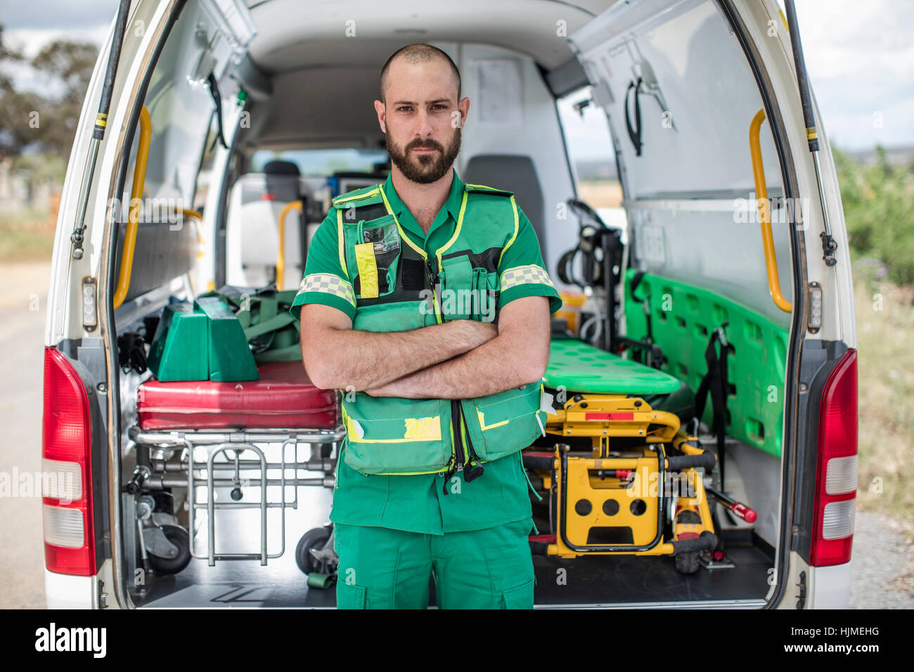 Paramedic standing with arms crossed in front of ambulance Stock Photo ...